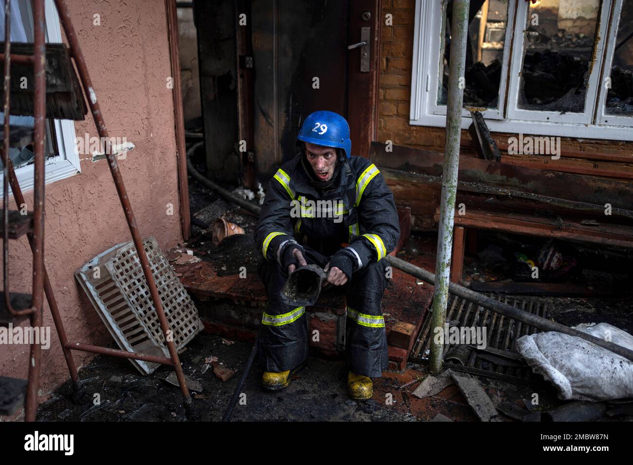 A Ukrainian firefighter takes a break from extinguishing a fire inside ...