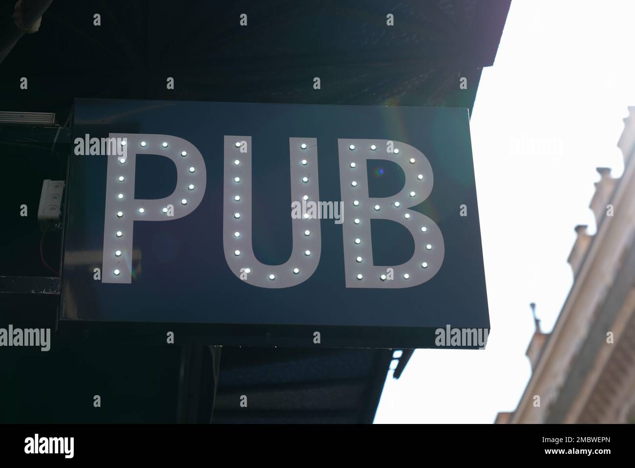 text pub neon sign on facade wall front building cafe bar in street ...