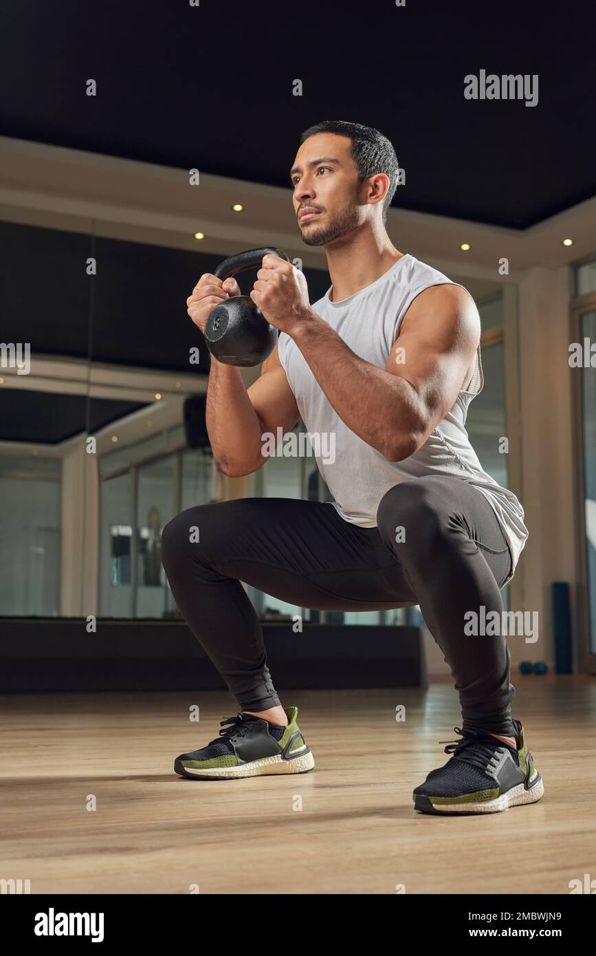 Getting stronger with each squat. Full length shot of a handsome young ...