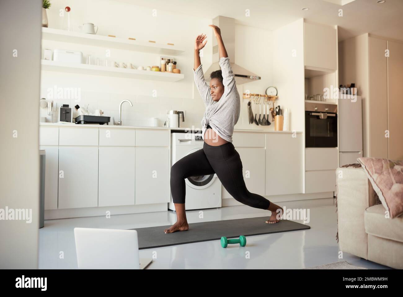 Expanding and extending her muscles. a young woman using a laptop while ...