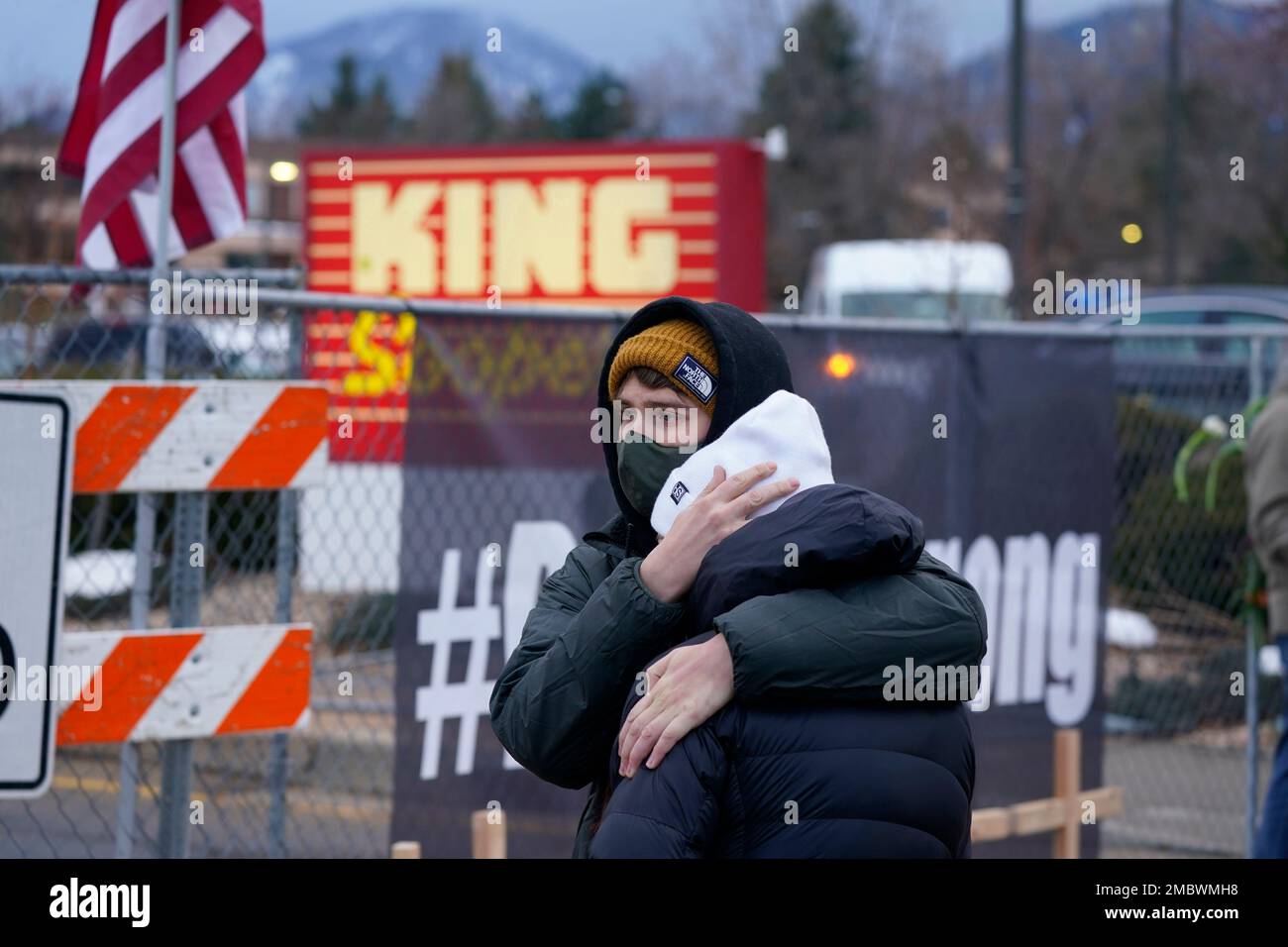 FILE - Mourners embrace along a fence put up around the parking lot ...