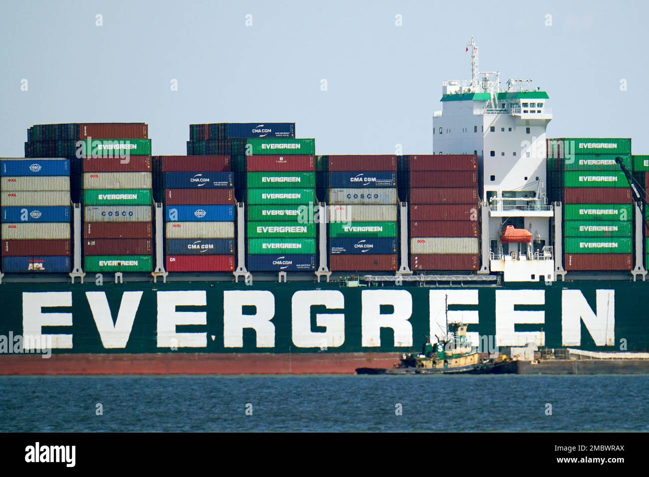 A tugboat, bottom, travels near a barge as crews try to dredge near the ...