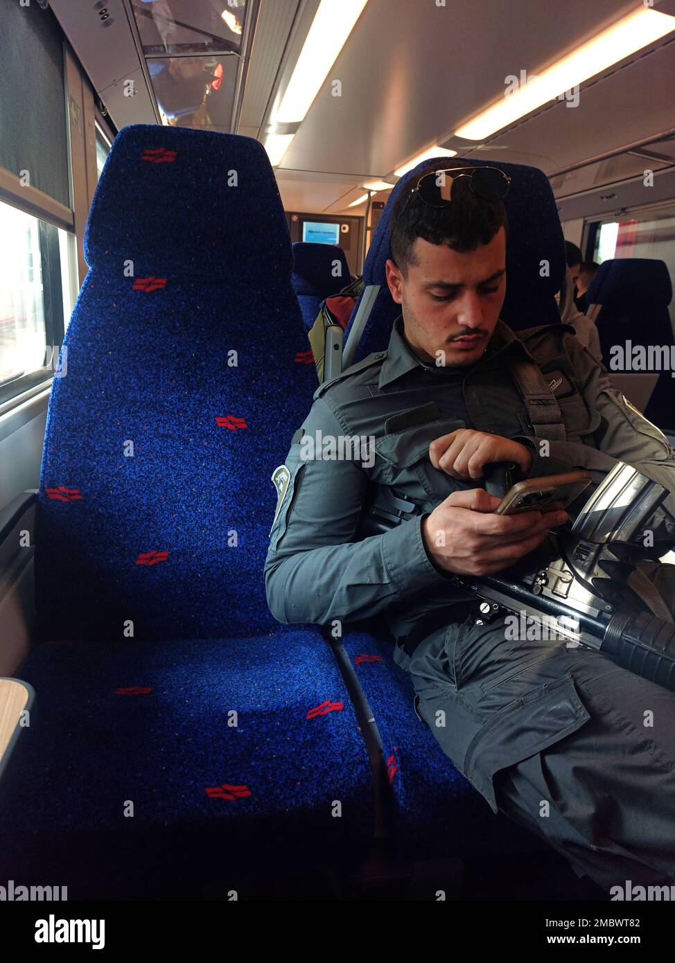 A member of the Israeli security force uses his smartphone as he rides ...