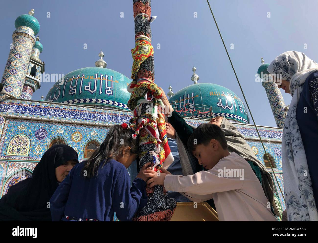 Afghan Shiite children and women kiss the holy mace for blessings ...