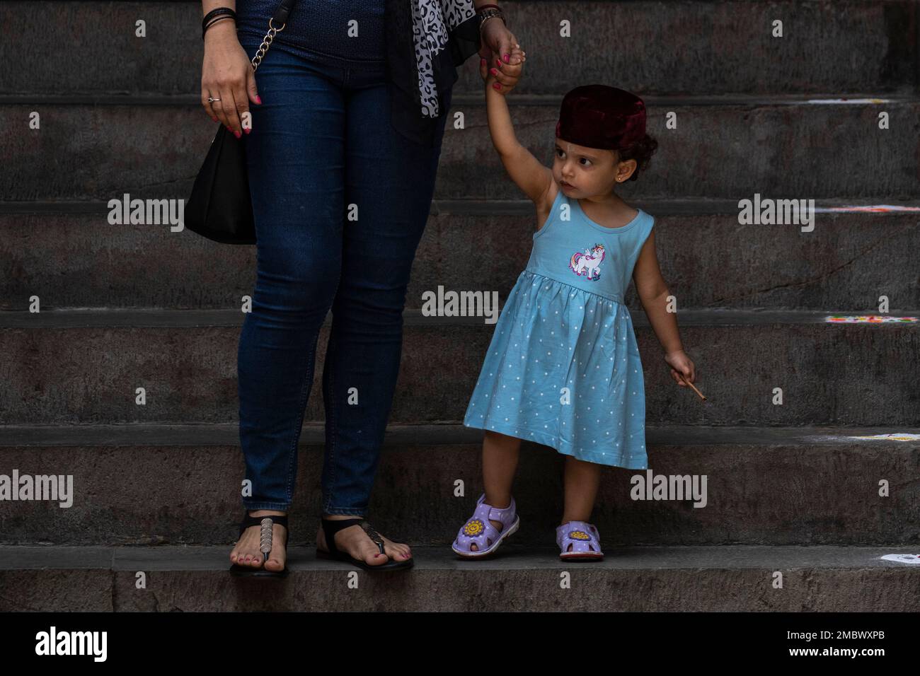 A Parsi girl holds the hand of her mother as they leave after offering ...