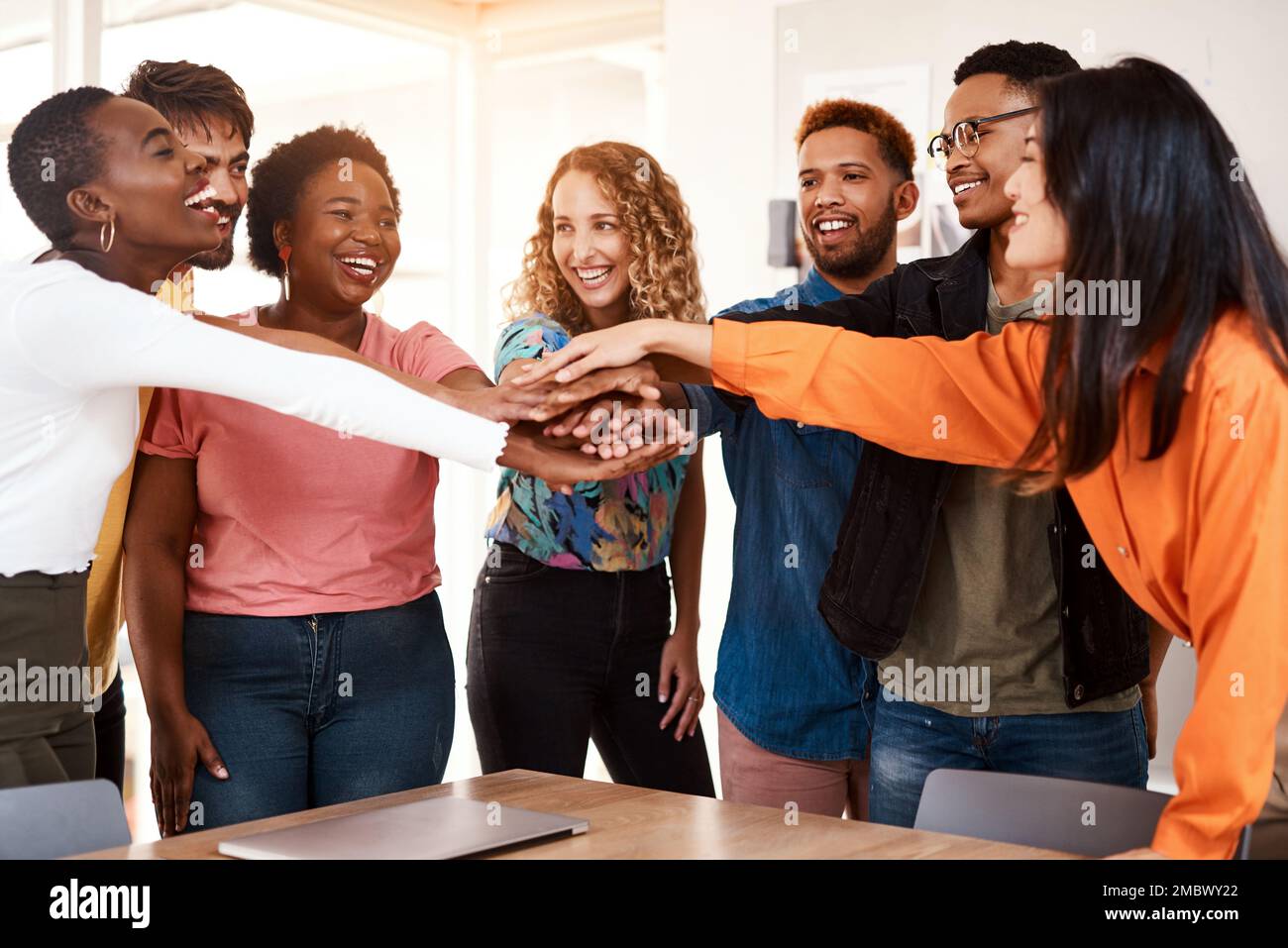 In it together. a group of young designers standing with their hands in a huddle in the office ...