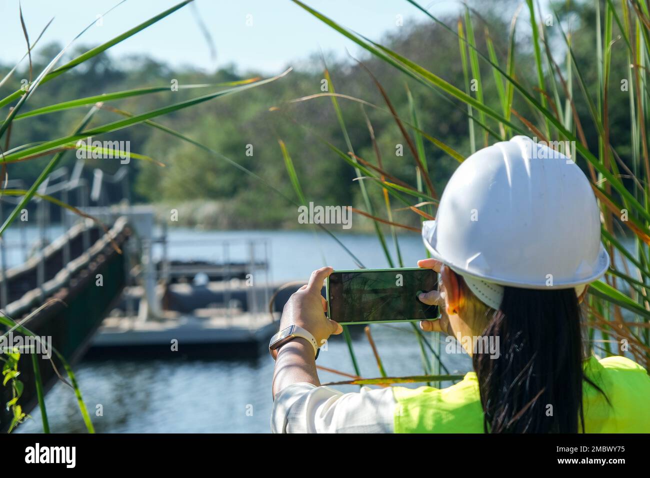 Environmental engineer uses a mobile phone to take pictures and record ...