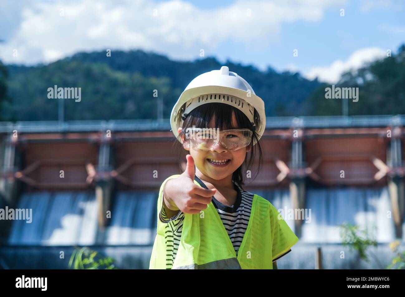 Portrait of a little girl engineer wearing a green vest and white ...
