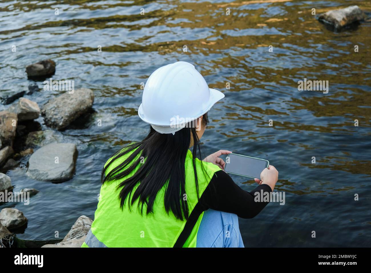 Environmental engineer uses a mobile phone to record water analysis ...