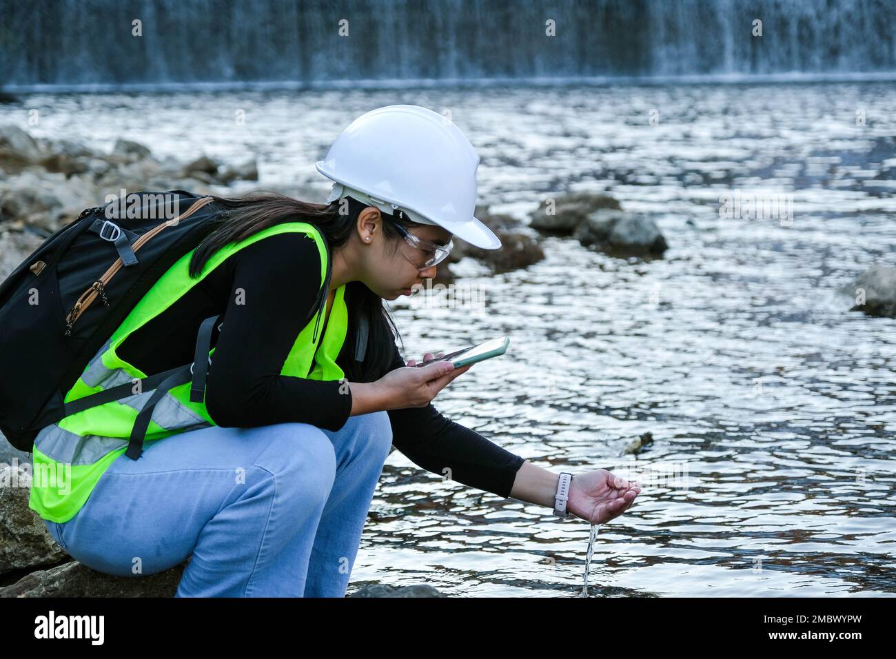 Environmental engineer uses a mobile phone to record water analysis ...