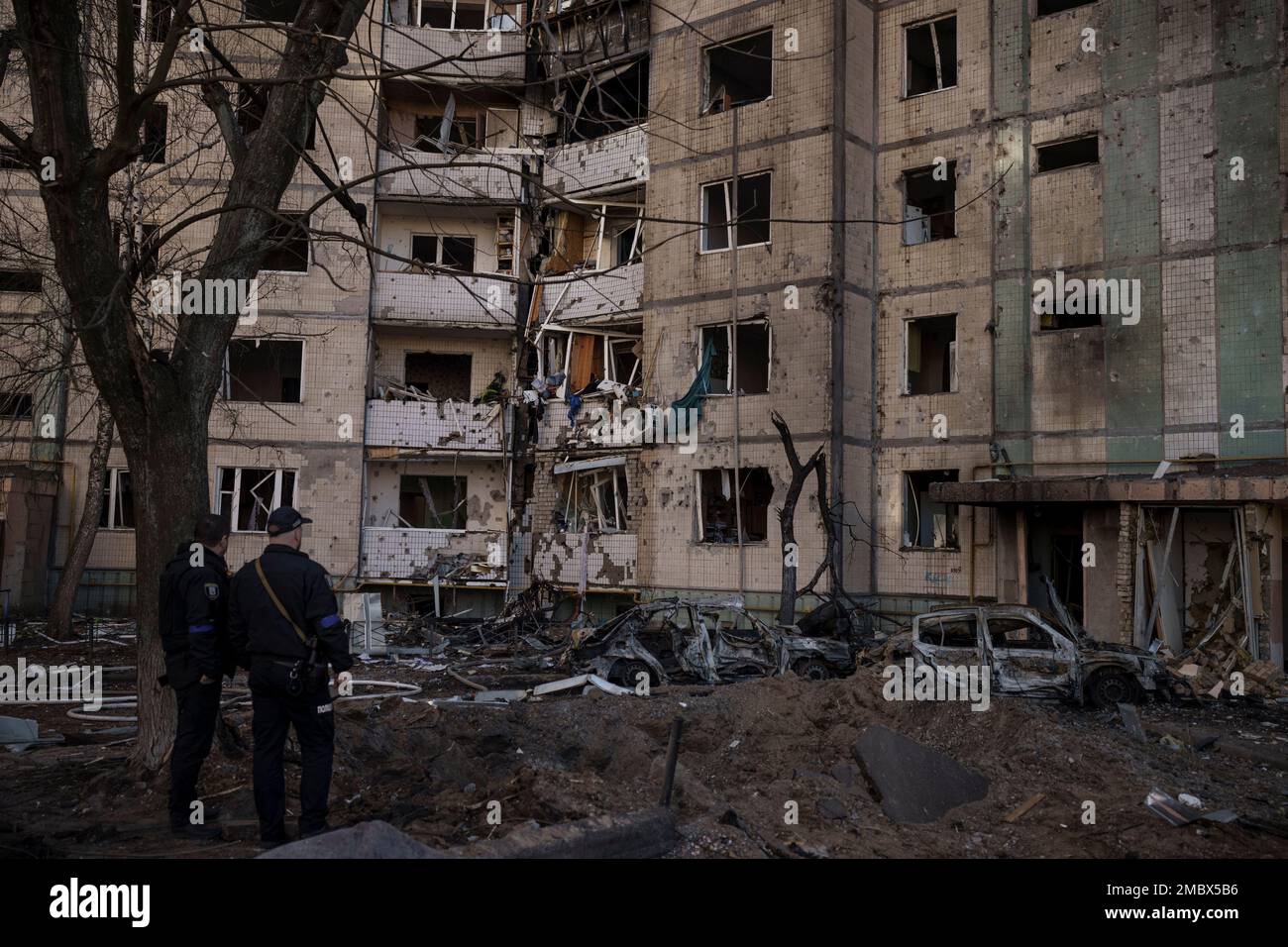 Ukrainian policemen look at a heavily damaged building after bombing in ...