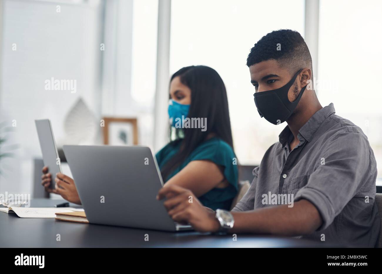 Business continues as usual. a young businessman working on a laptop in ...