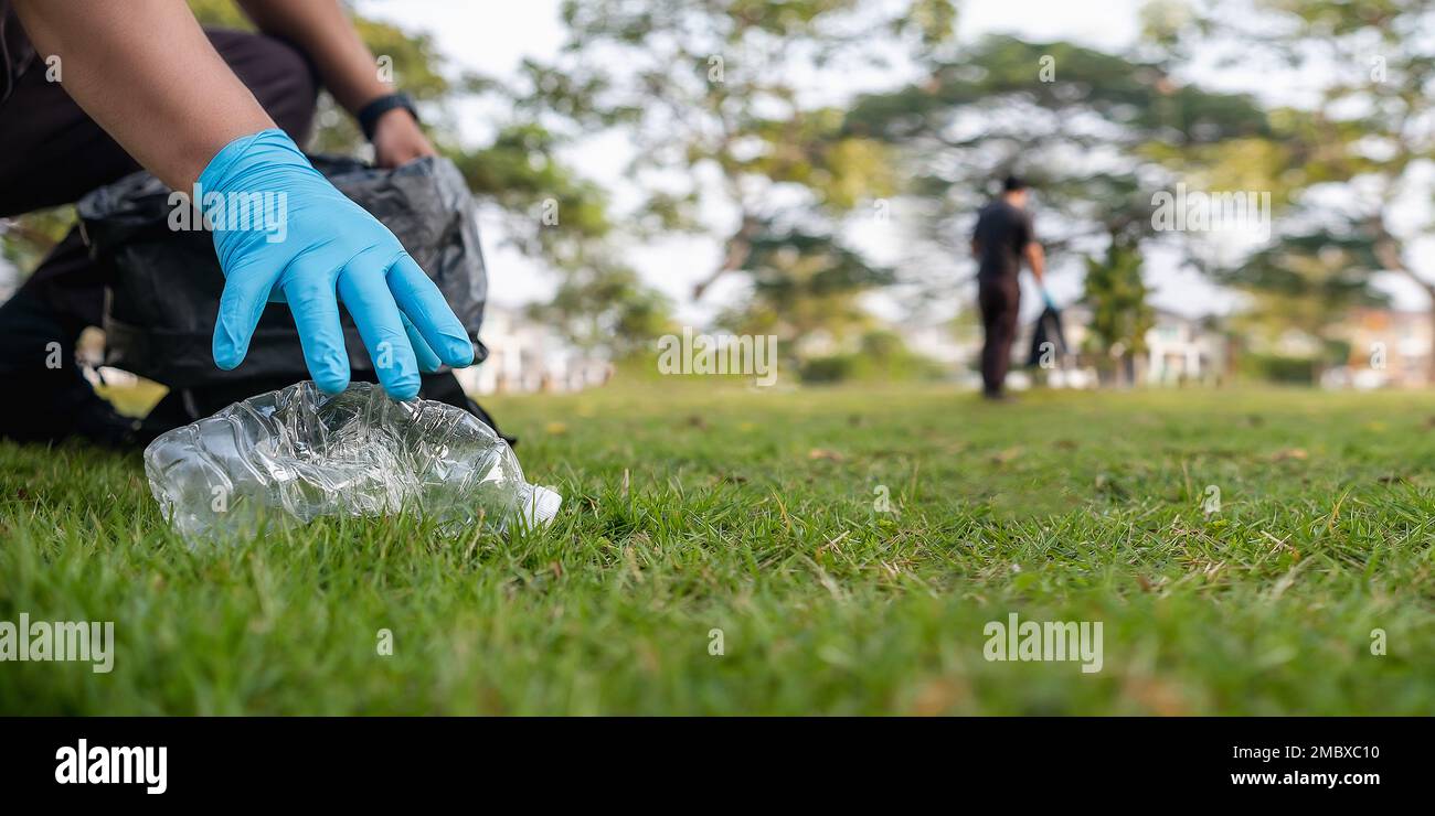 Volunteer man collecting trash and reusing plastic cleanup to recycle ...
