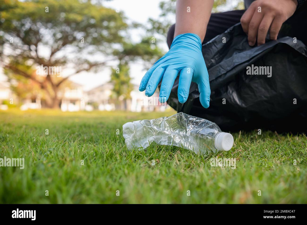 Volunteer man collecting trash and reusing plastic cleanup to recycle ...