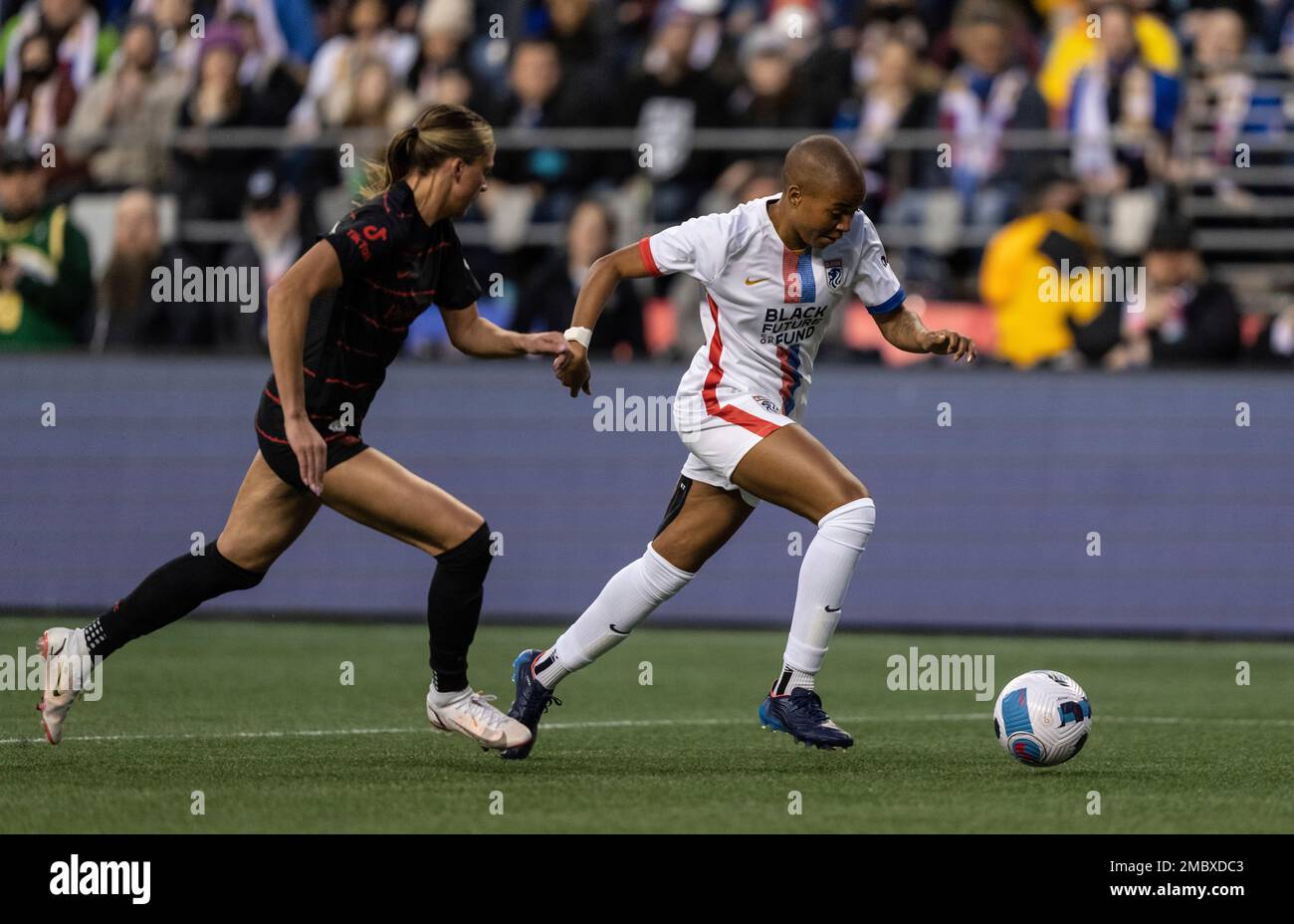 OL Reign forward Tziarra King, right, dribbles the ball against ...