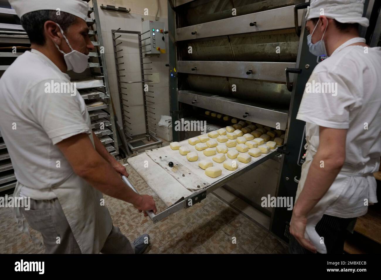 Bakers prepares bread to be baked inside a bakery laboratory in ...