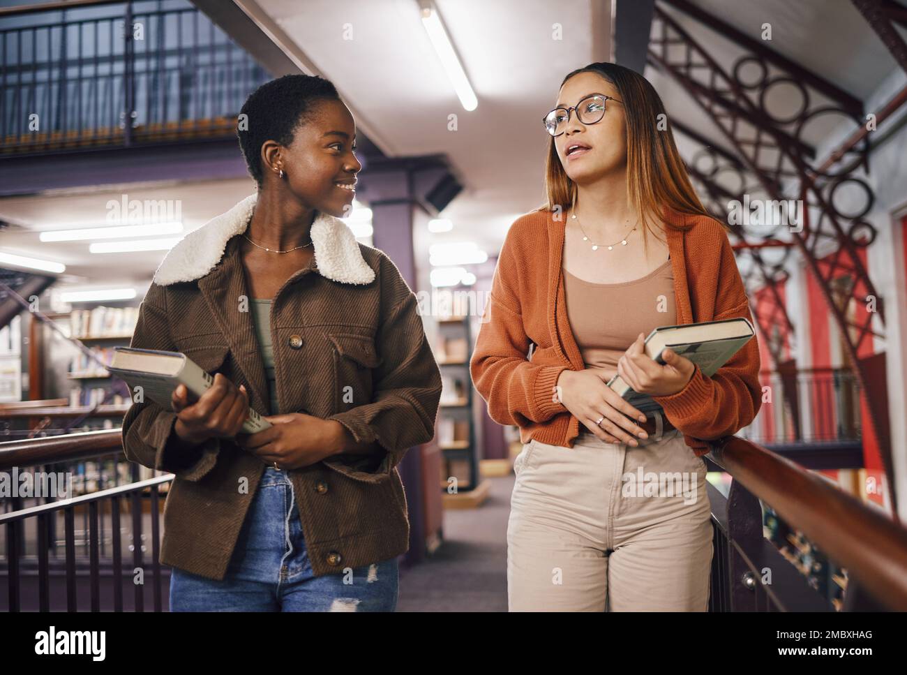 College students, library books and women talking about education and ...