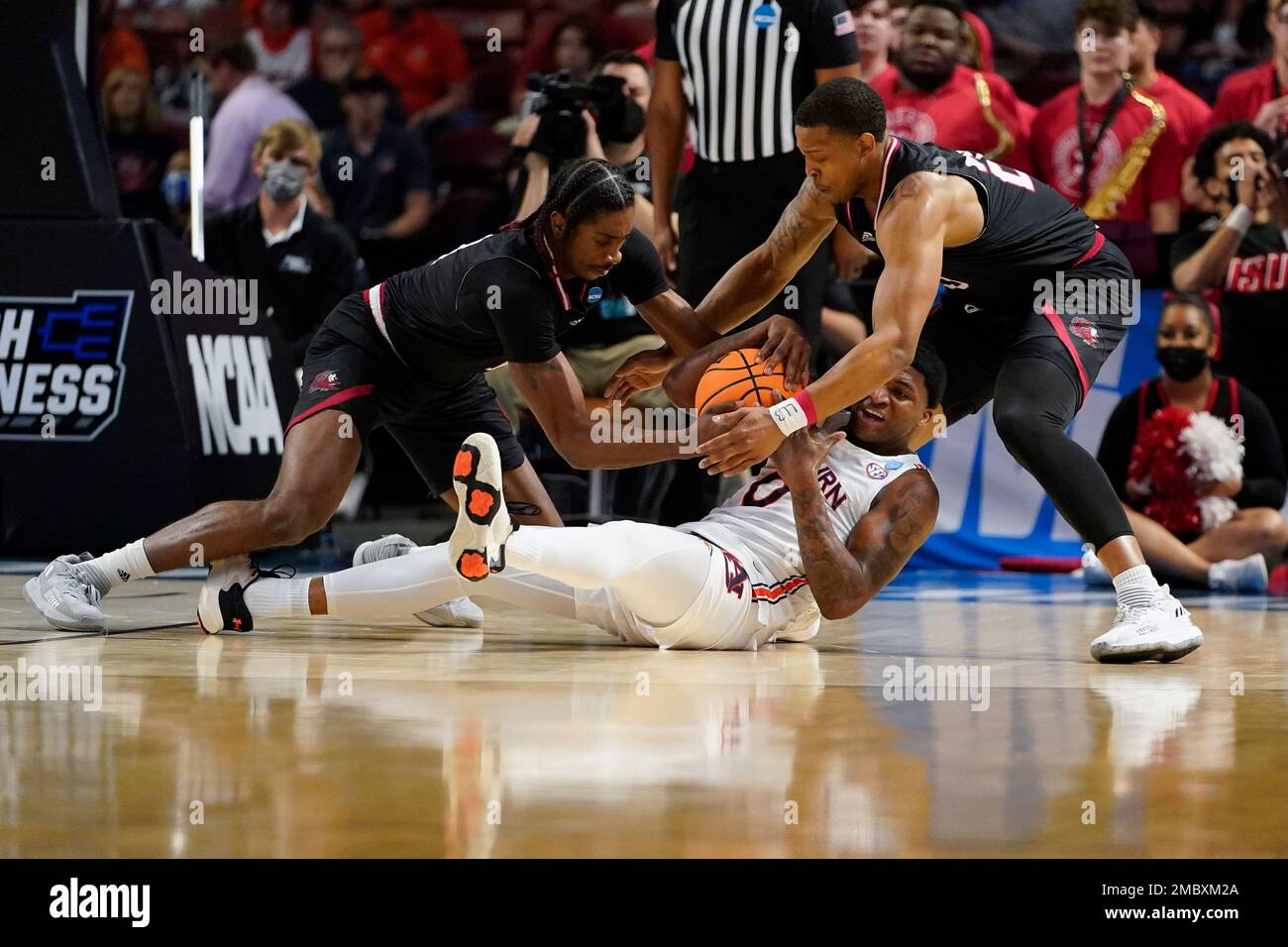 Auburn guard K.D. Johnson, middle, battles for a loose ball between ...