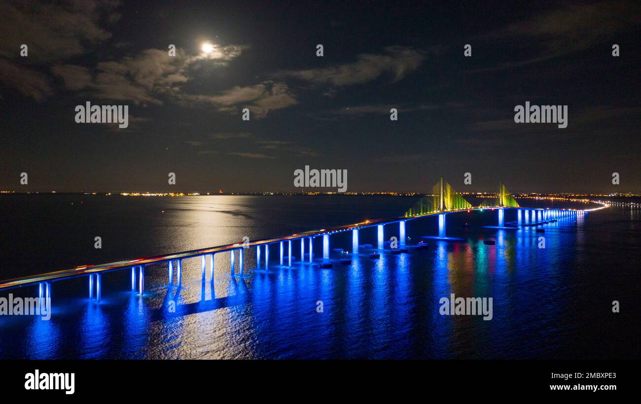 The moon rises over an illuminated Bob Graham Sunshine Skyway bridge as ...