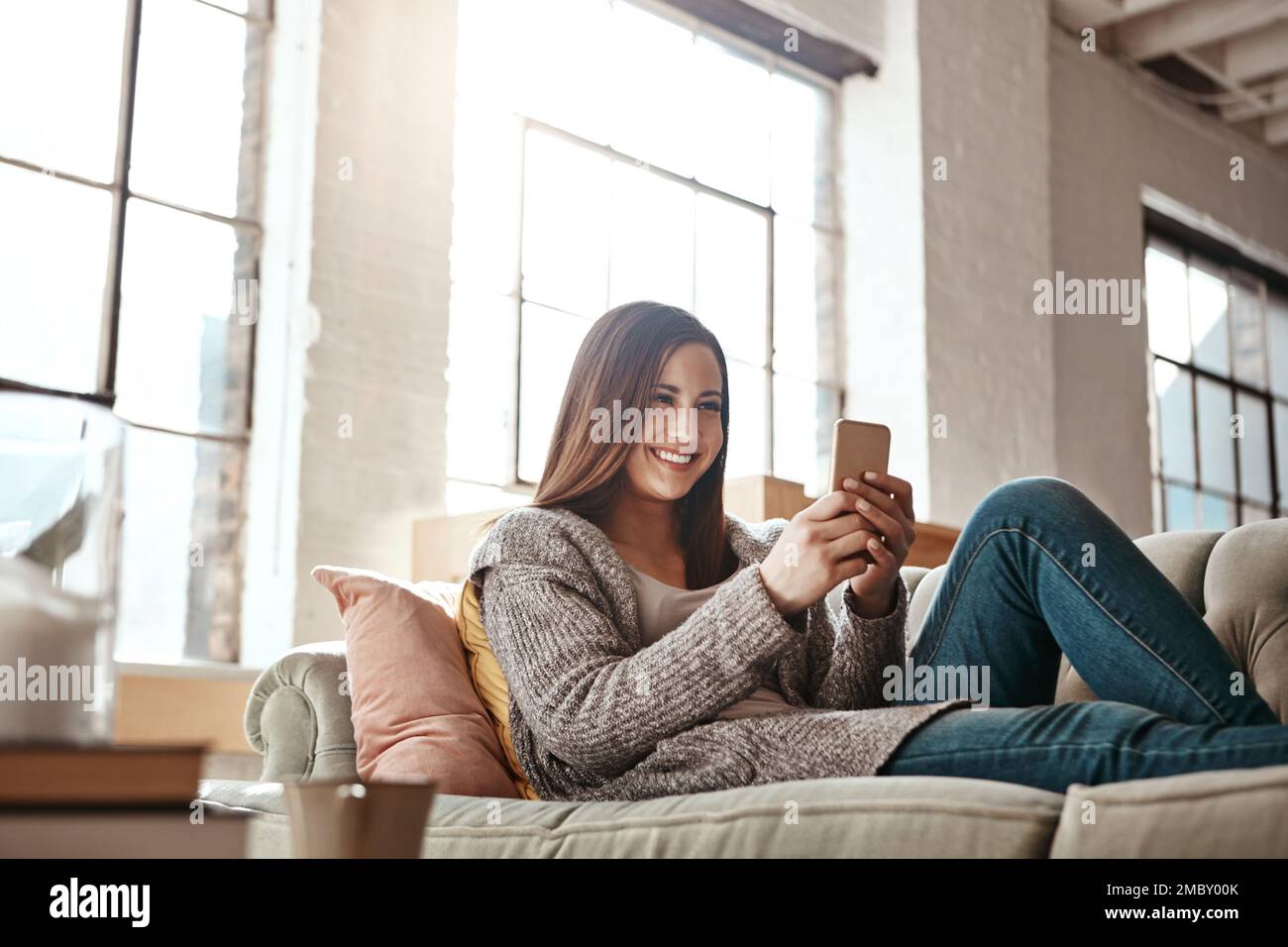 Relax, phone and woman on a sofa, happy and texting on social media ...