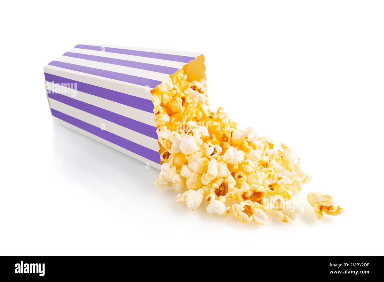 Tasty cheese popcorn falling out of a purple striped carton bucket ...