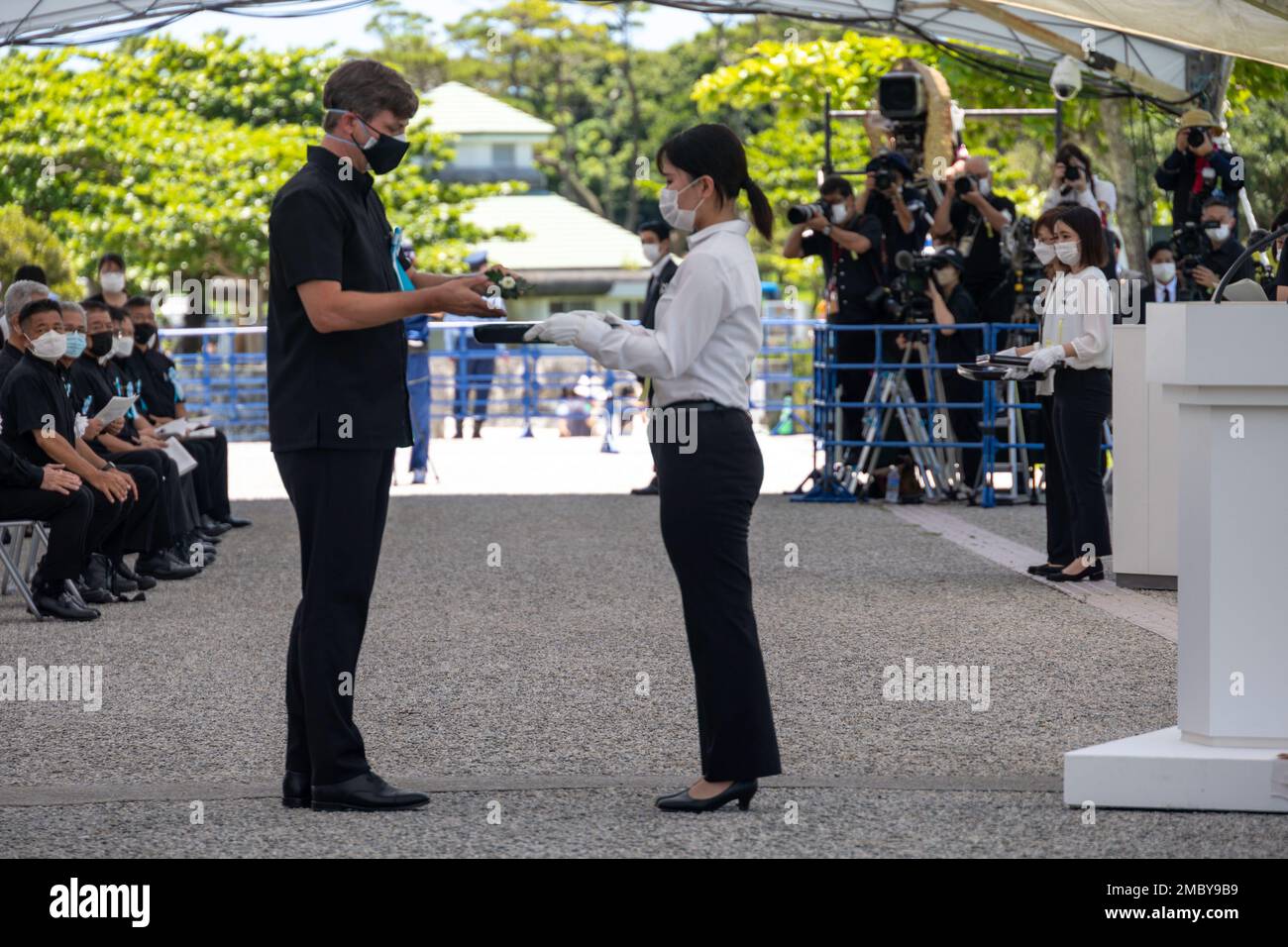 U.S. Consul General Matthew Dolbow, receives a flower to lay on a ...