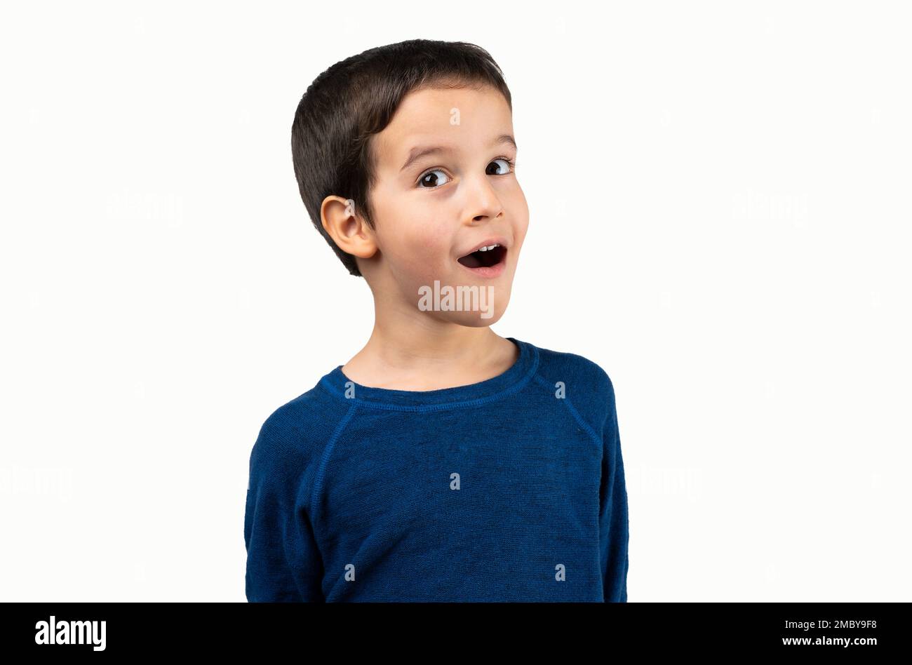 Dark haired little child making listen gesture with shocked face ...