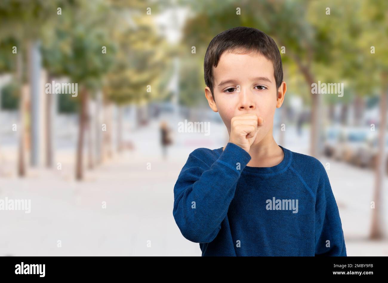 Young little boy kid wearing blue shirt walking down the street feeling ...