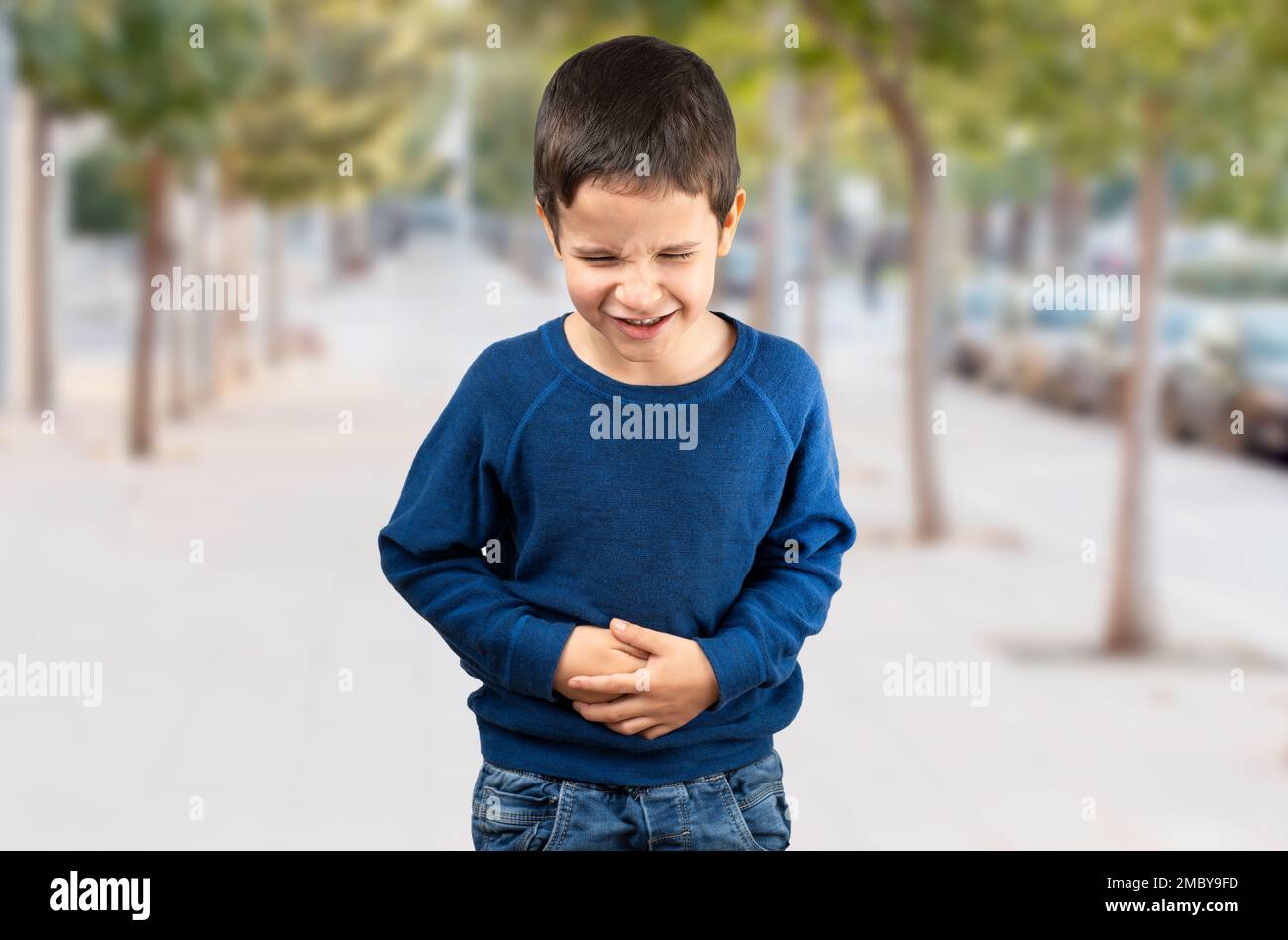Young little boy kid wearing blue shirt walking down the street with ...