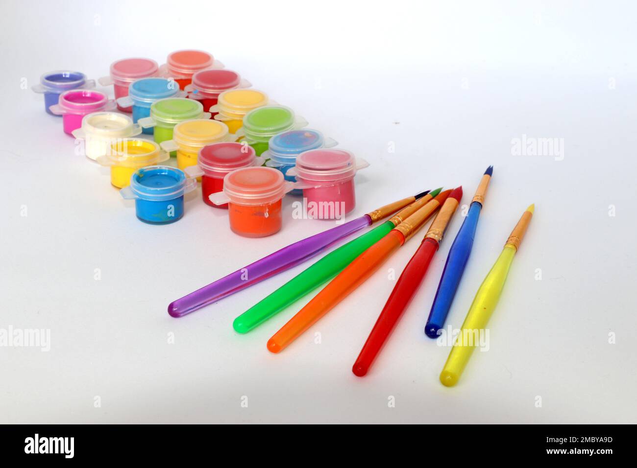 colorful containers of paint and paintbrushes isolated on white ...