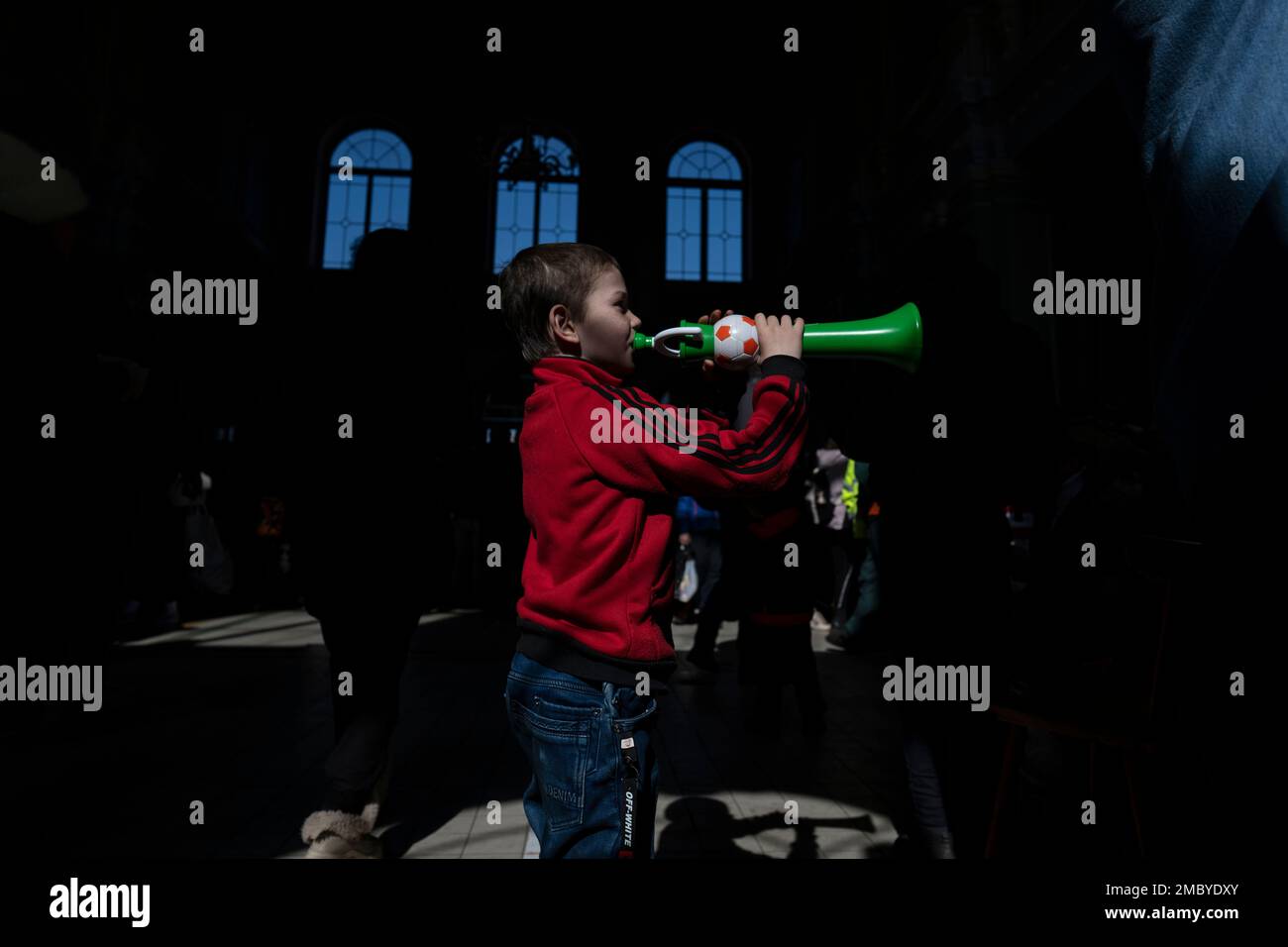 A boy plays with a toy horn as he and his family who fled the war in ...