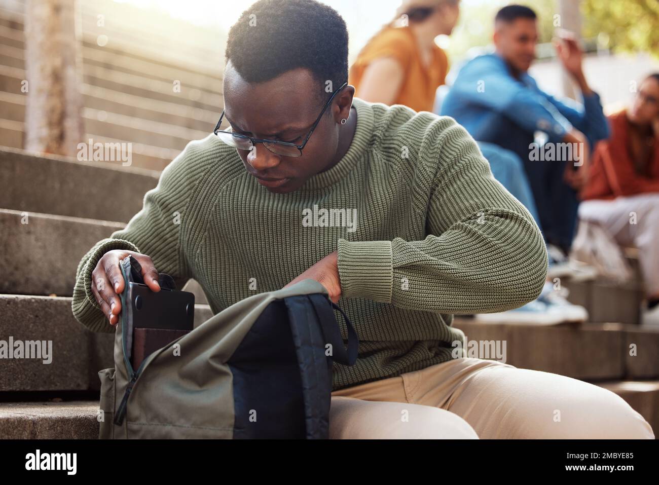 University, student and black man looking in bag at campus for learning ...