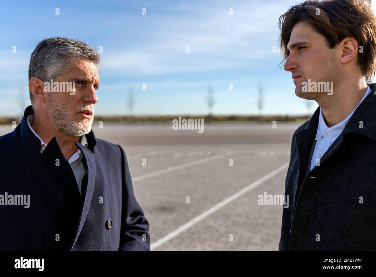 Confident businessmen in classy clothes looking at each other while ...