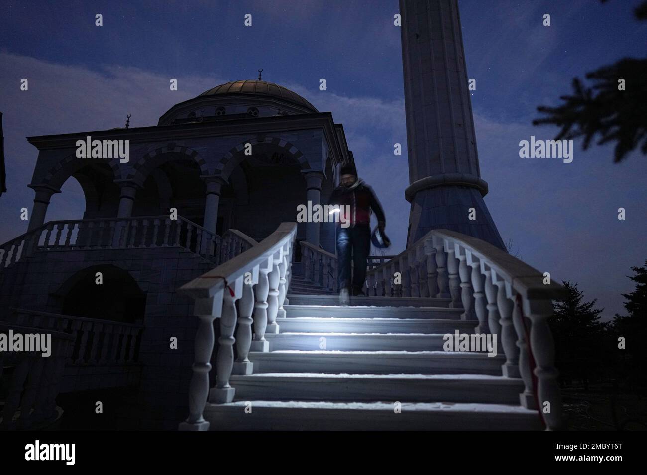 Turkish imam Mehmet Yuce walks down the steps after evening pray in a ...