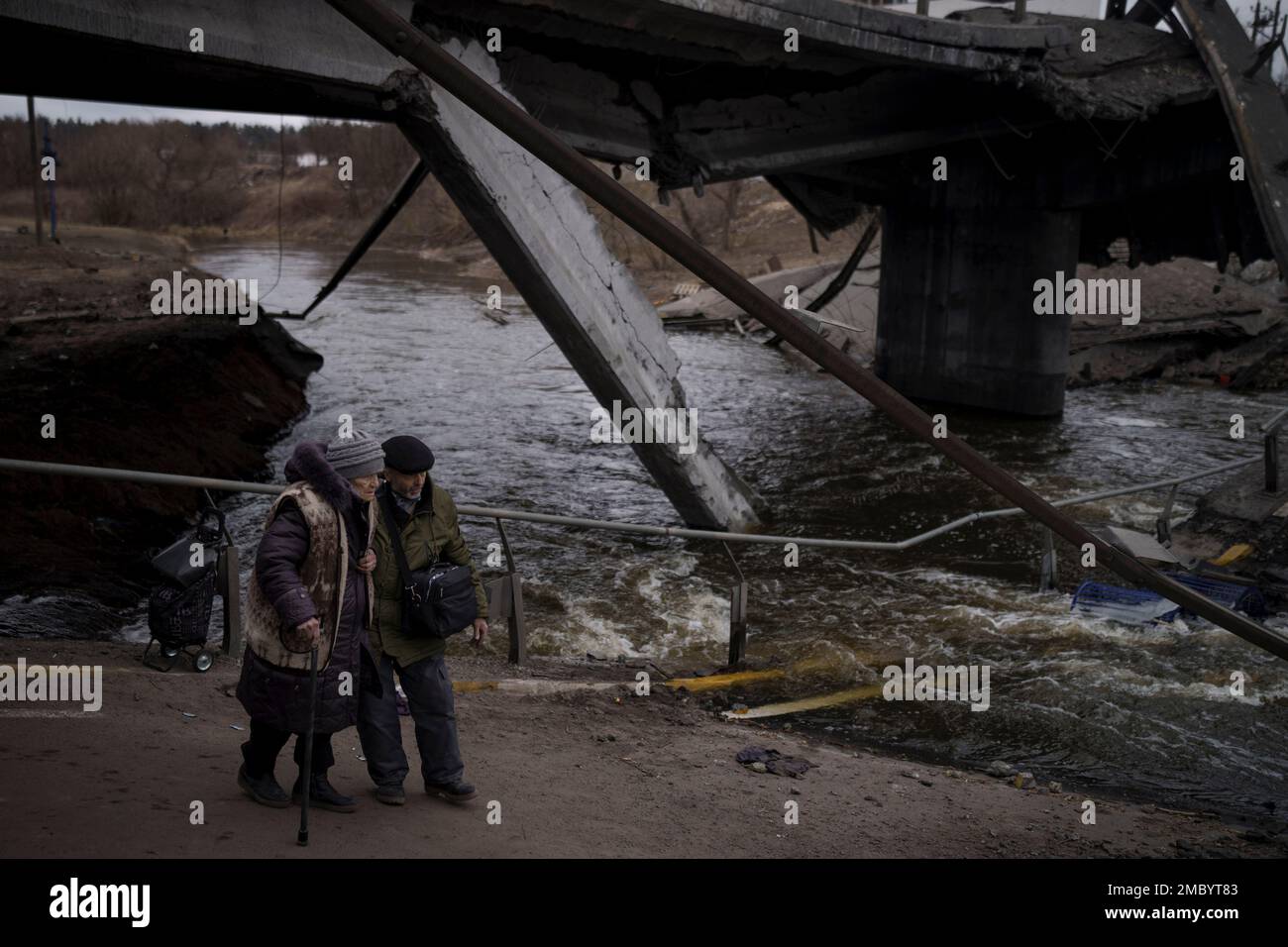 Elderly residents cross a destroyed bridge while fleeing Irpin ...