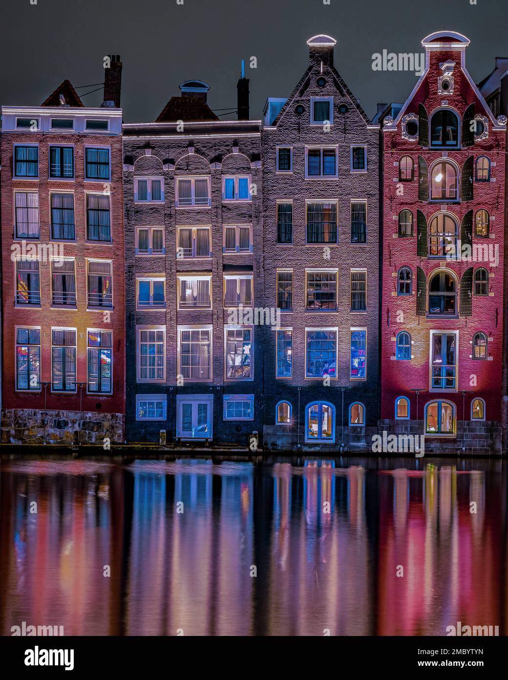 Amsterdam at night with dancing colorful houses at the Amsterdam canals ...