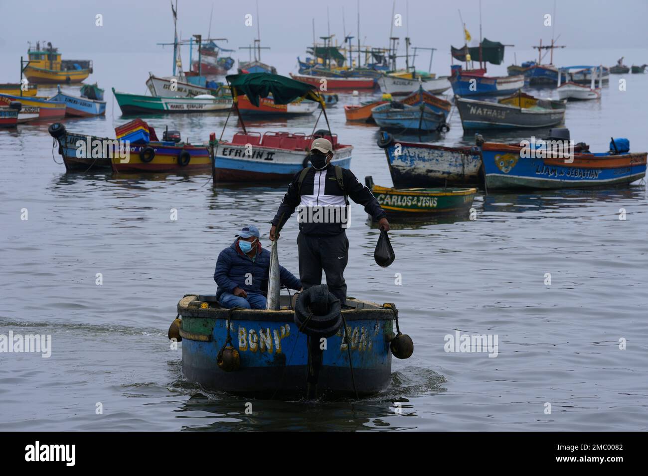 FILE - A fisherman holds a fish he caught in waters contaminated with ...