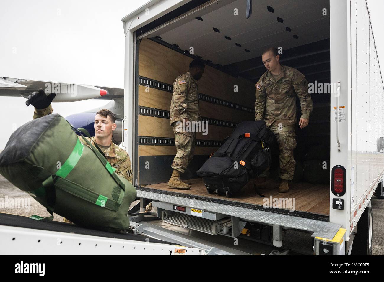 A solder with the U.S. Army's 3rd Infantry Division loads the cargo ...