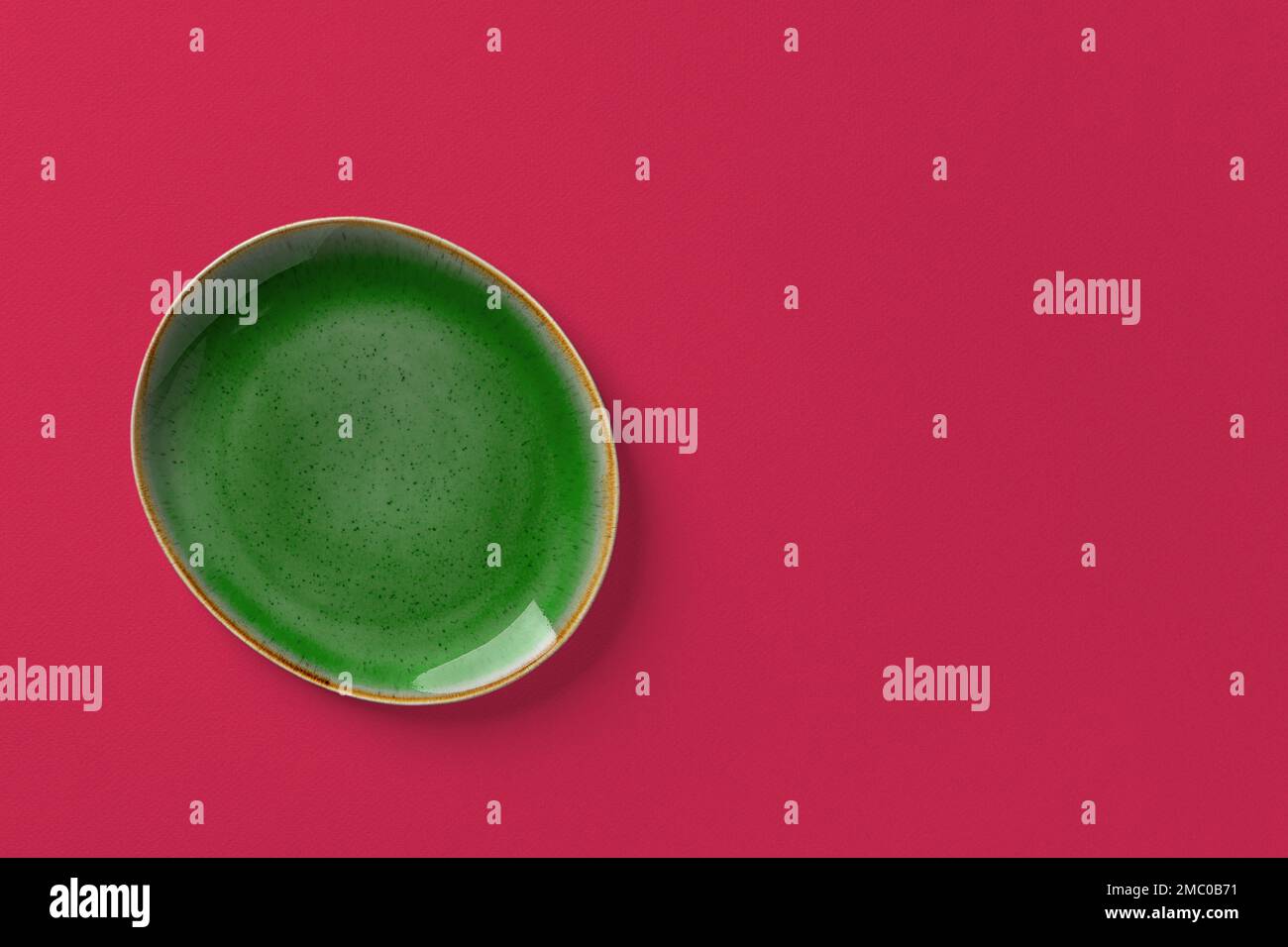 Green plate over viva magenta background. Modern empty dishes and ...
