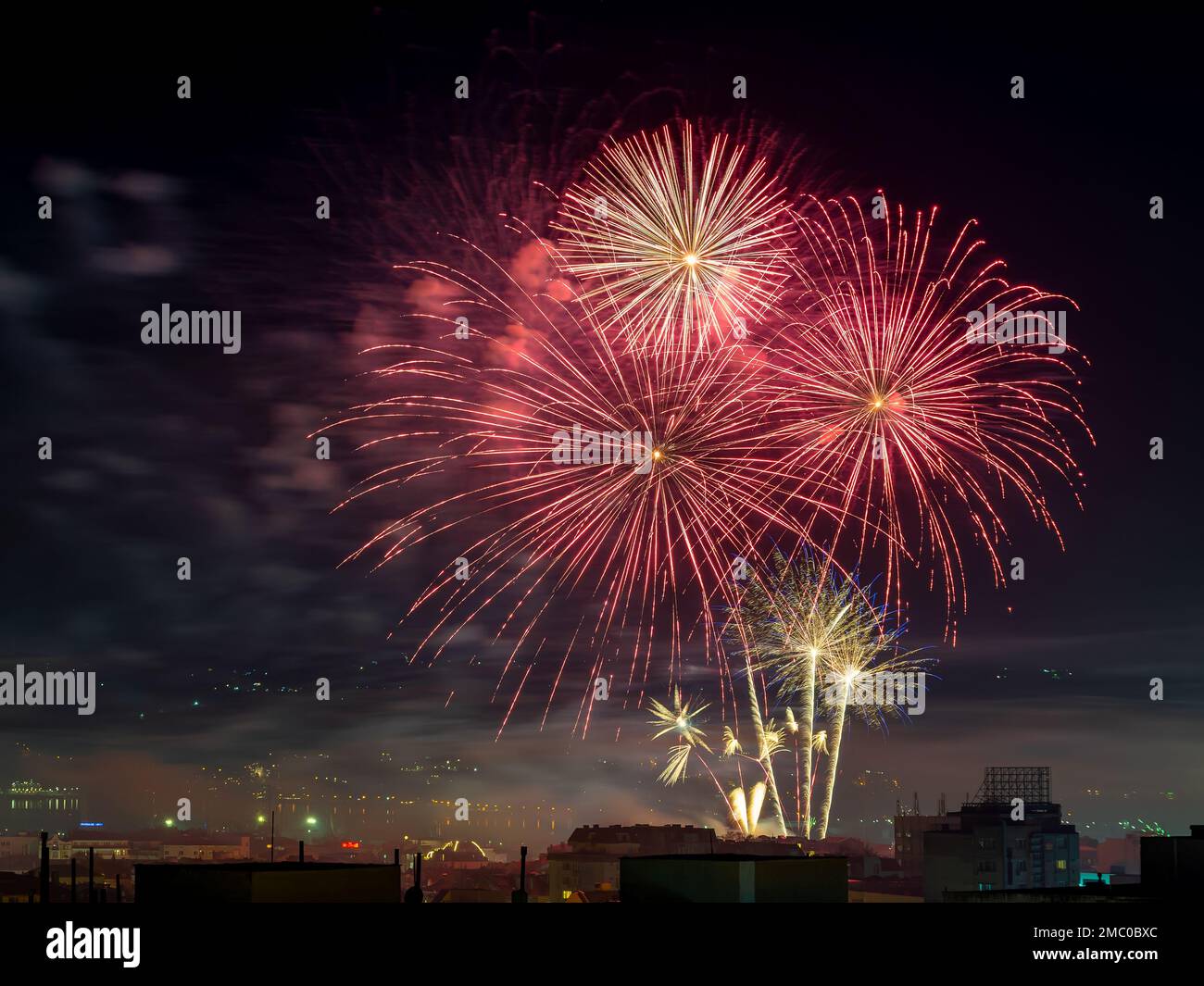 Red firework bursts and sparks in the dark sky. Bright fireworks ...