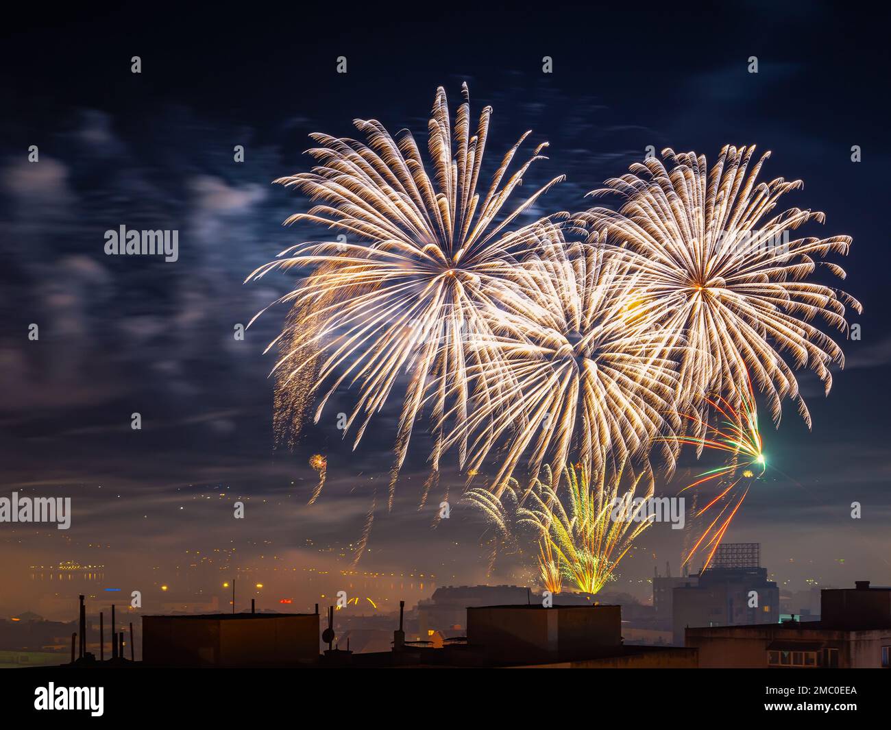 Glowing fireworks in the night sky. Bright firework display while city ...