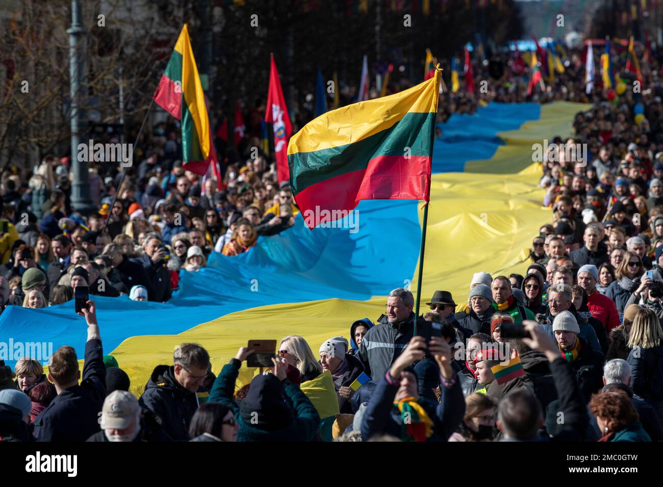 People carry a giant Ukrainian flag to protest against the Russian ...