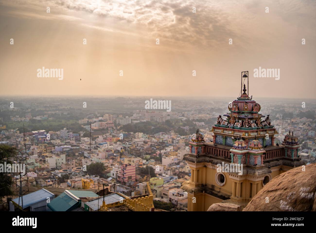 The roof of the ancient temple in Trichy India with the cityscape in ...