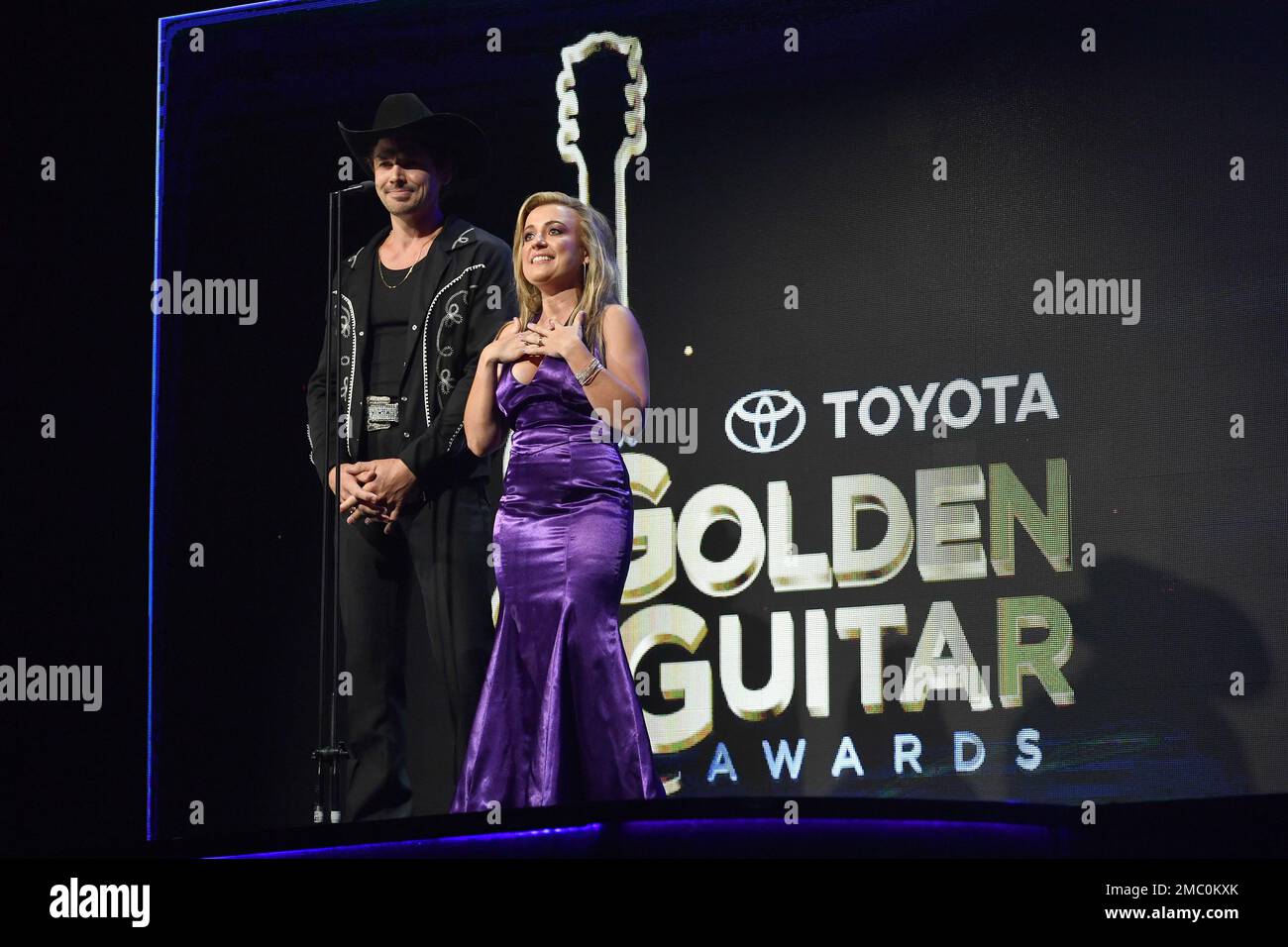 Jesse Anderson (left) and Kirsty Lee Akers present an award at the ...