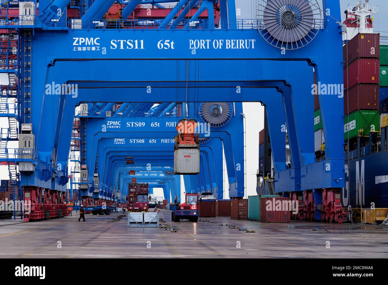 Gantry cranes move containers onto transporters at the port, in Beirut ...