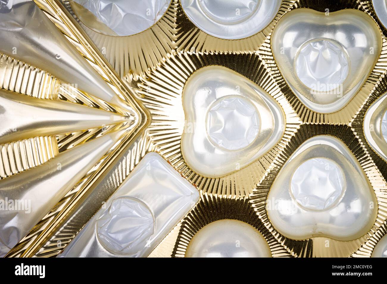 Close up shot of empty box of chocolates. Shiny gold plastic texture of ...
