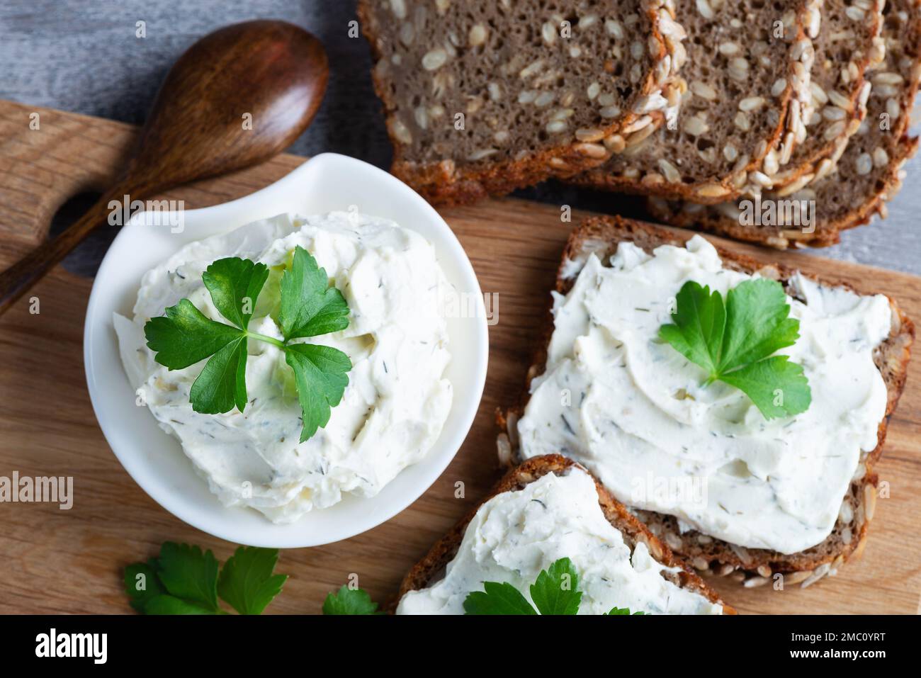 Home made bread on a wooden cutting board with curd cheese and ricotta ...