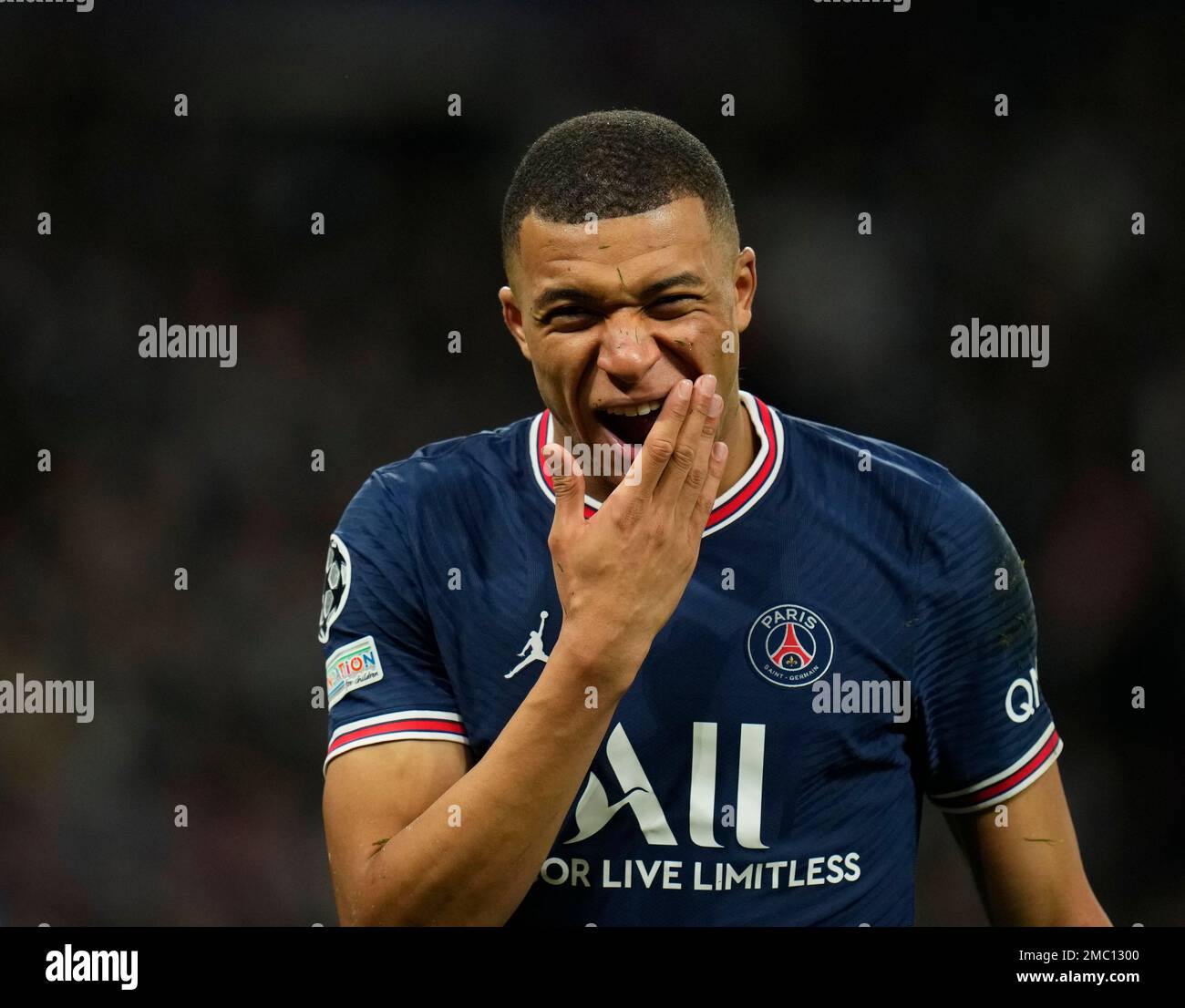 PSG's Kylian Mbappe rubs his cheek after falling on the side of his ...
