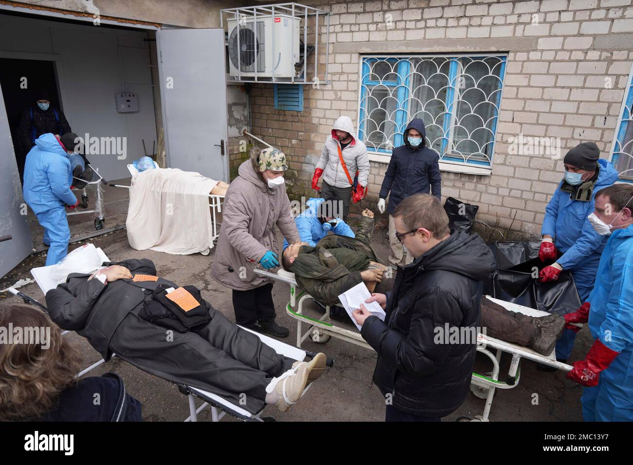 Dead bodies are prepared before being put into body bags and buried in ...