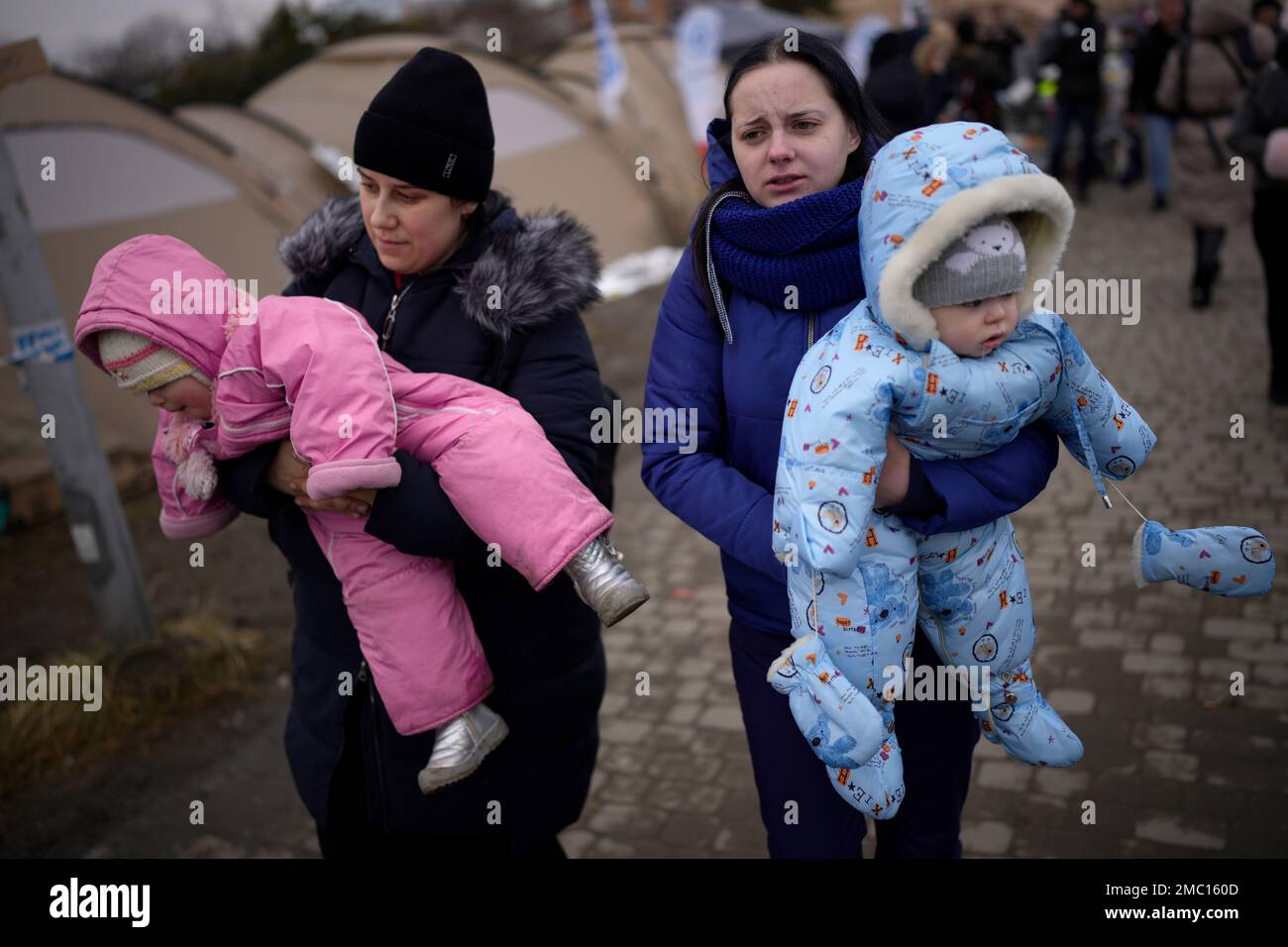 Women carry children after crossing from Ukraine in Medyka, Poland ...